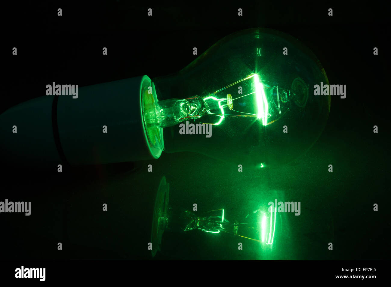 Green light bulb turned over on black background Stock Photo - Alamy