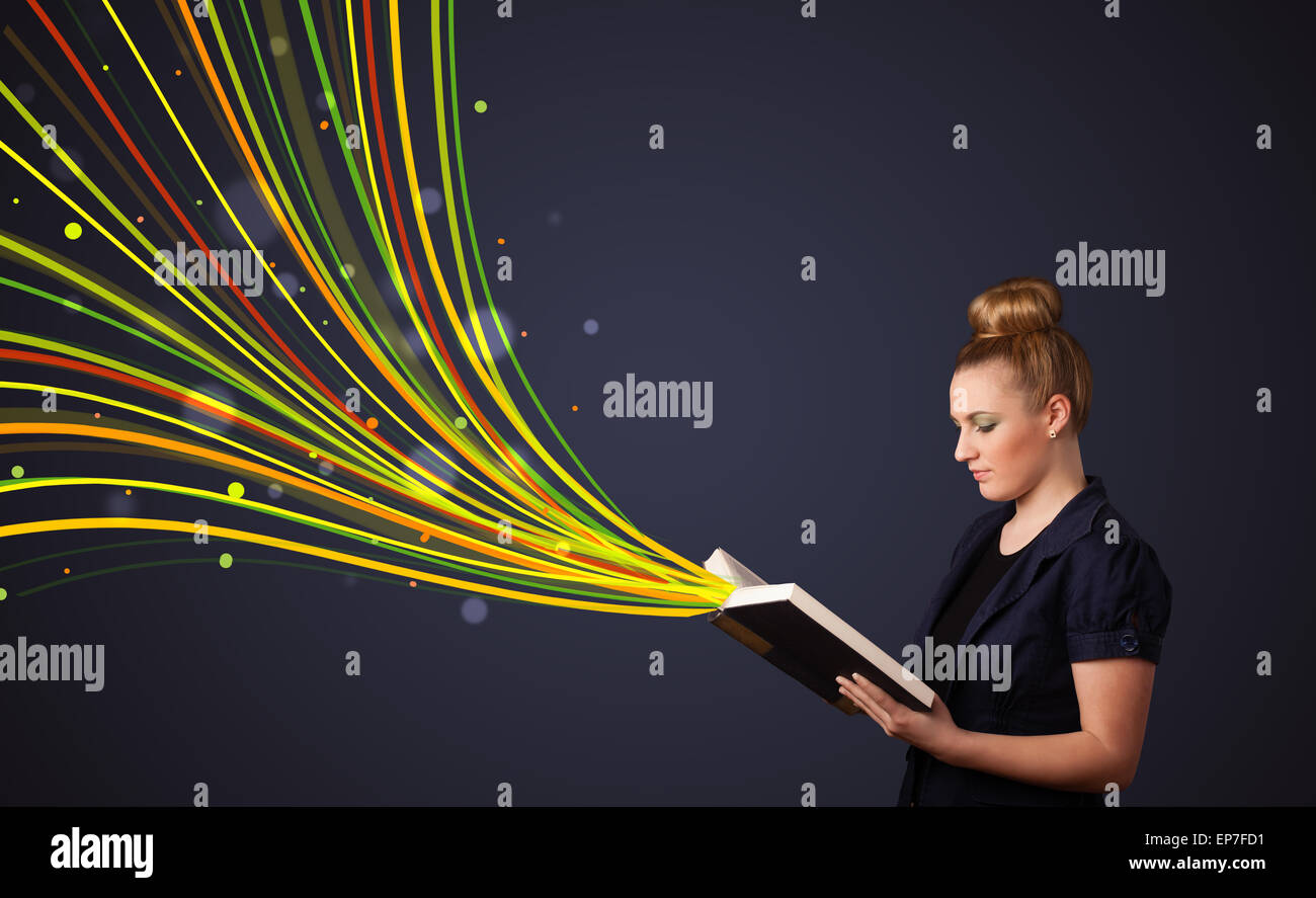 Pretty young woman reading a book while colorful lines are coming out ...