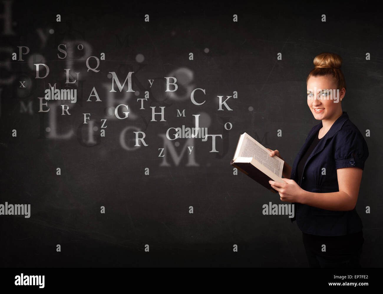 Young lady reading a book with alphabet letters Stock Photo - Alamy