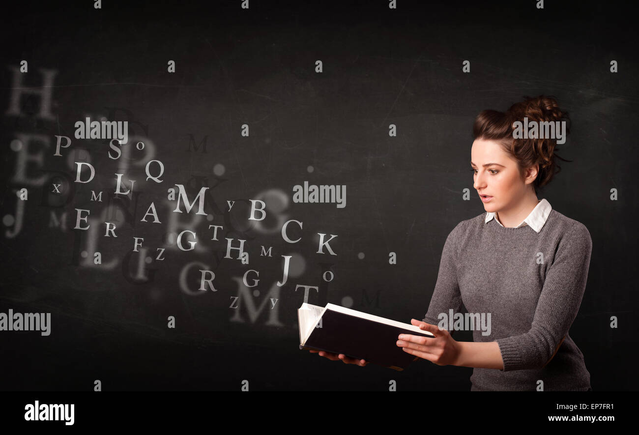 Young lady reading a book with alphabet letters Stock Photo - Alamy