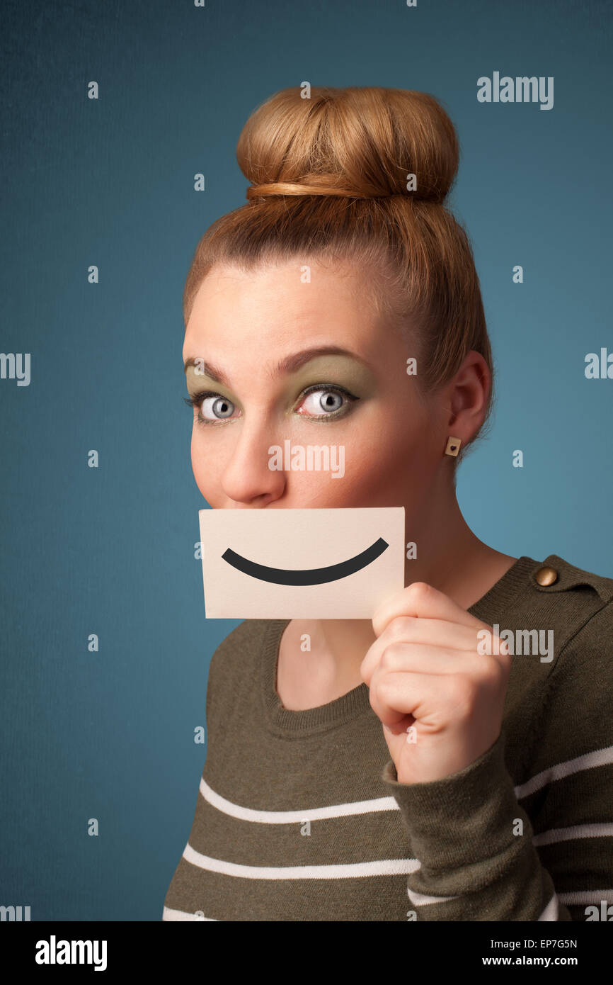 Happy pretty woman holding card with funny smiley Stock Photo - Alamy