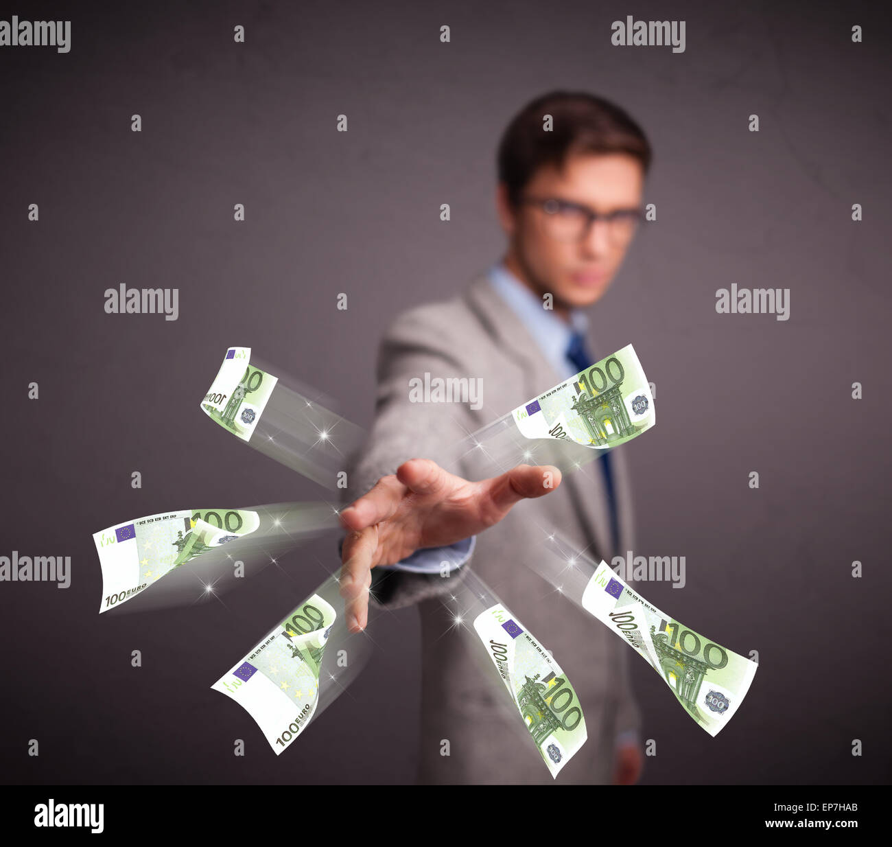Young man standing and throwing money Stock Photo - Alamy