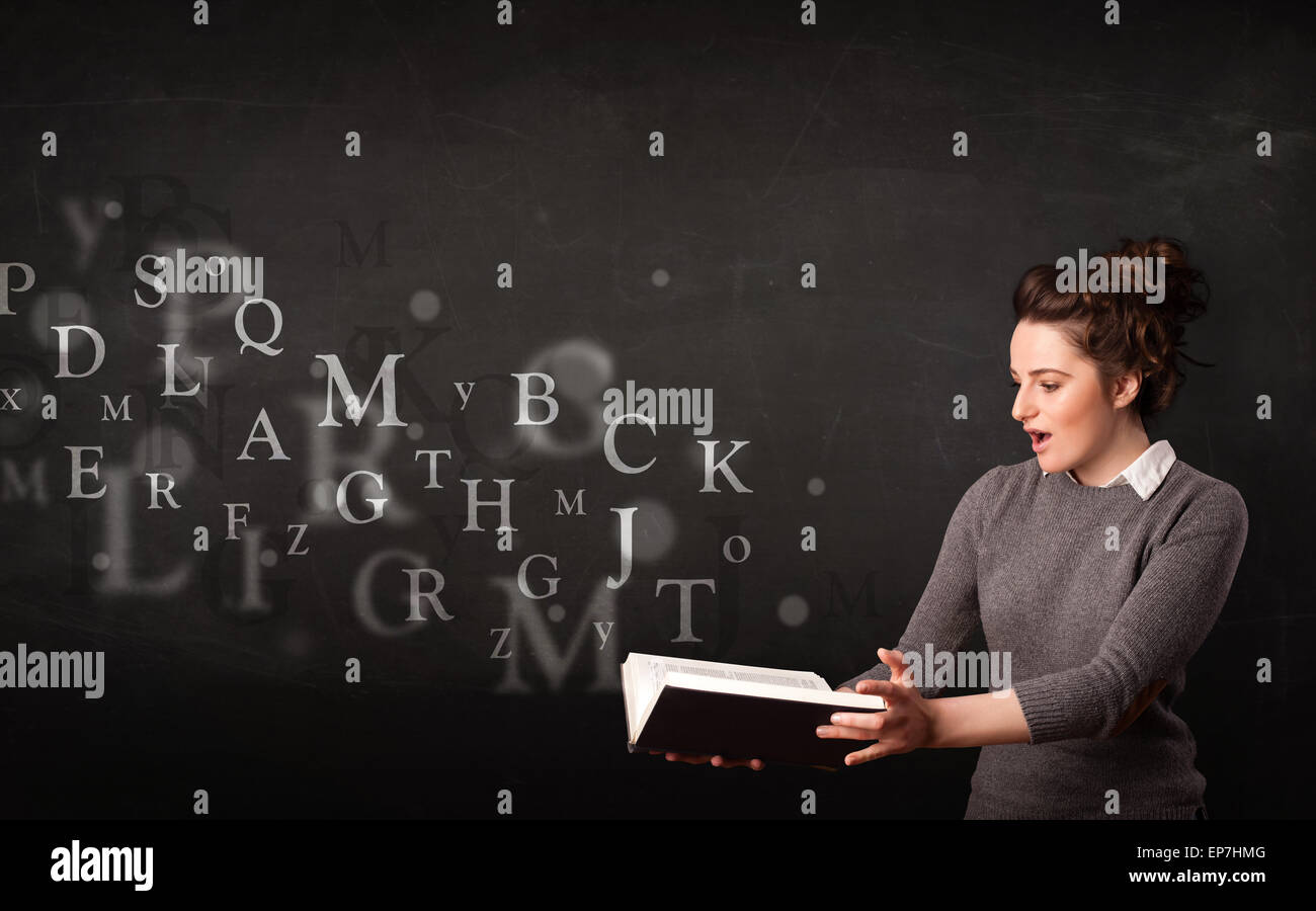 Young lady reading a book with alphabet letters Stock Photo - Alamy