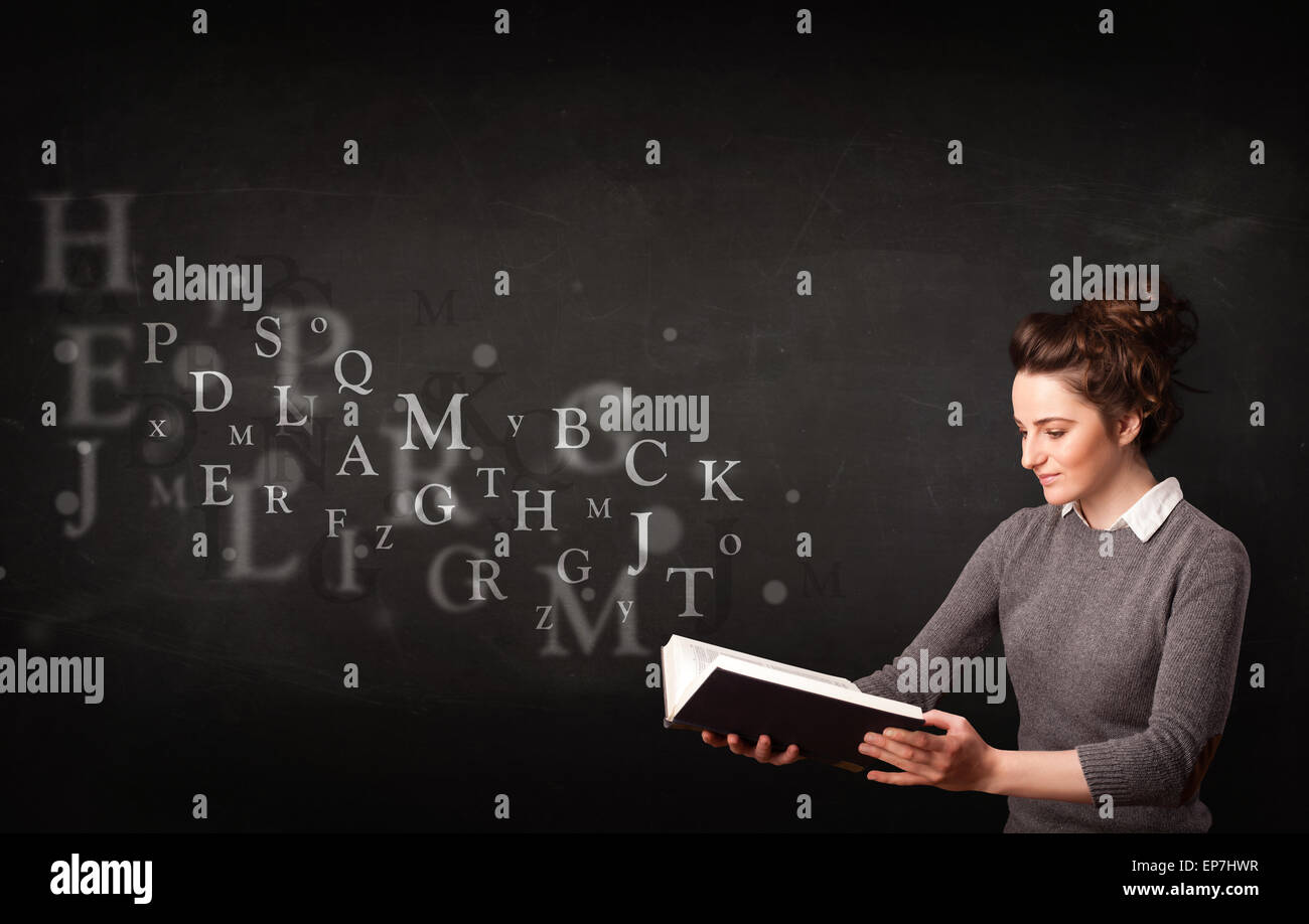 Young lady reading a book with alphabet letters Stock Photo - Alamy