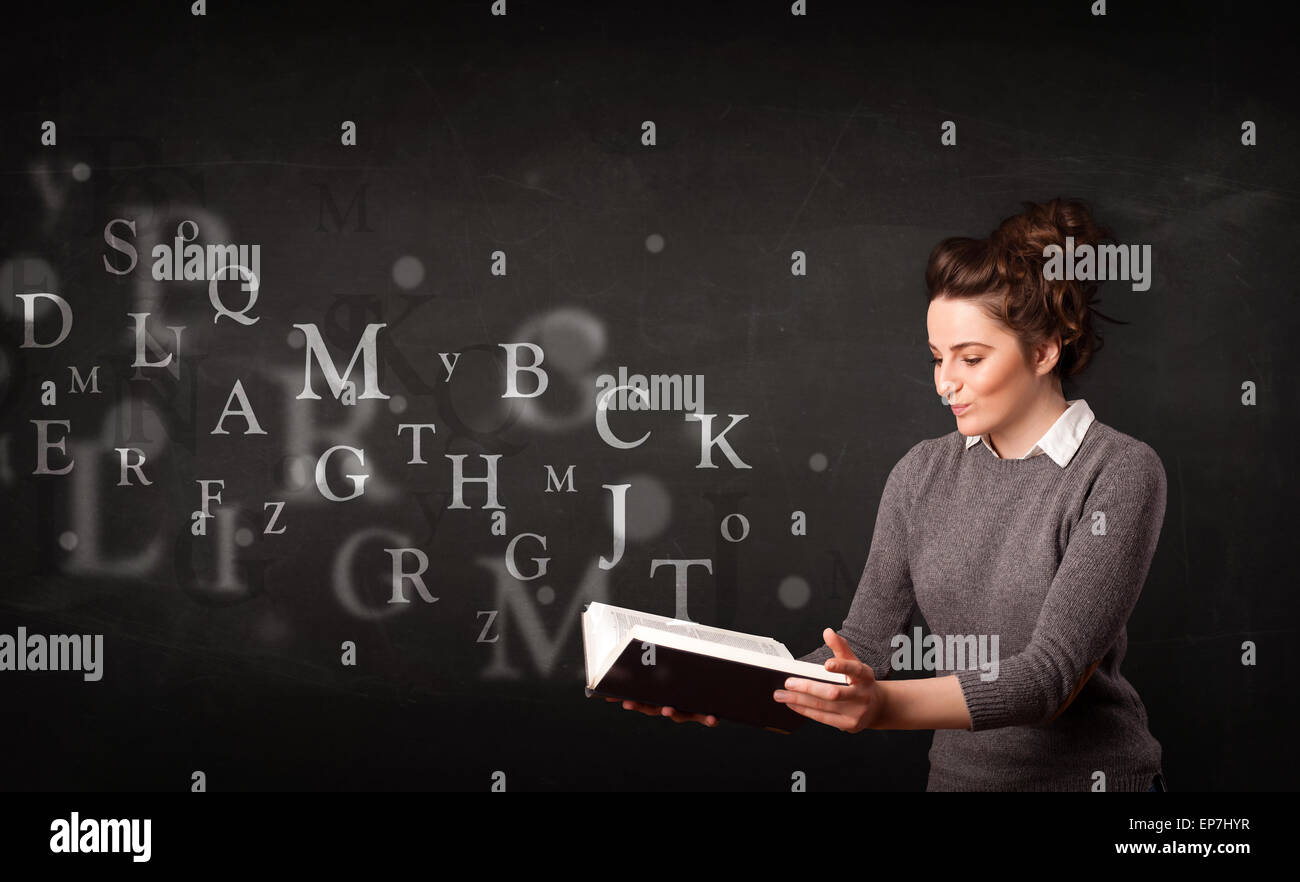 Young lady reading a book with alphabet letters Stock Photo - Alamy