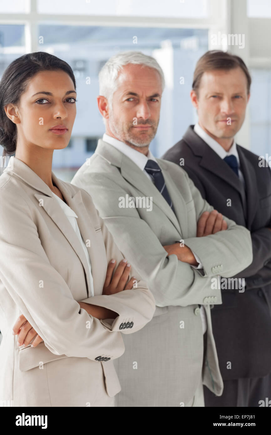 Three serious business people standing together Stock Photo - Alamy