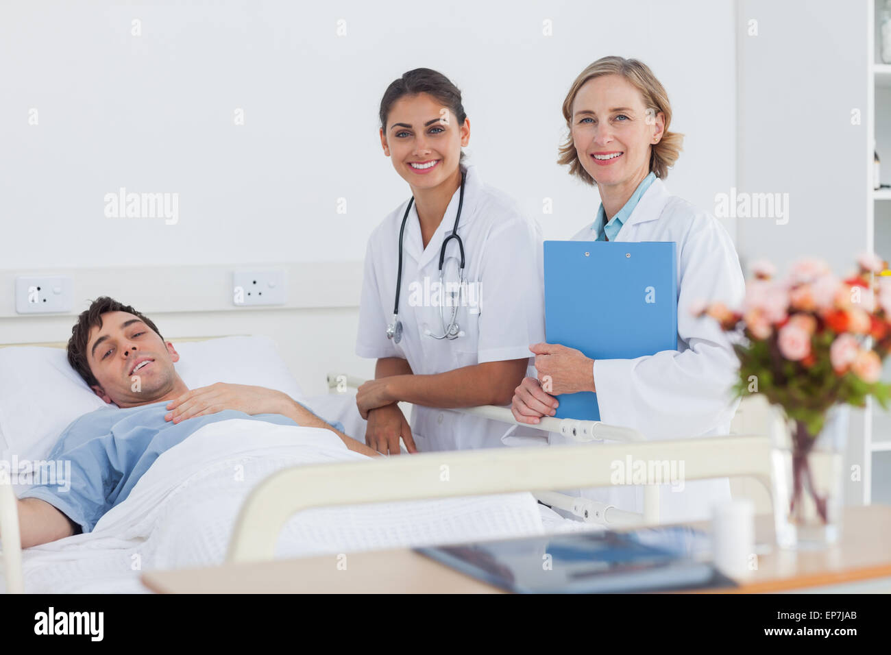Two doctors and a patient looking at the camera Stock Photo - Alamy