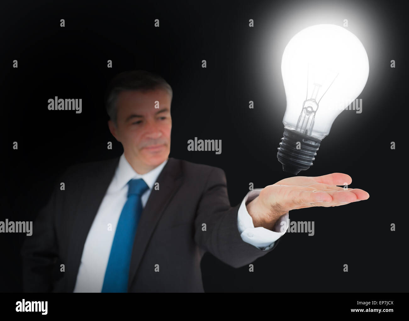 Light bulb lighting up inside the hand of businessman Stock Photo - Alamy