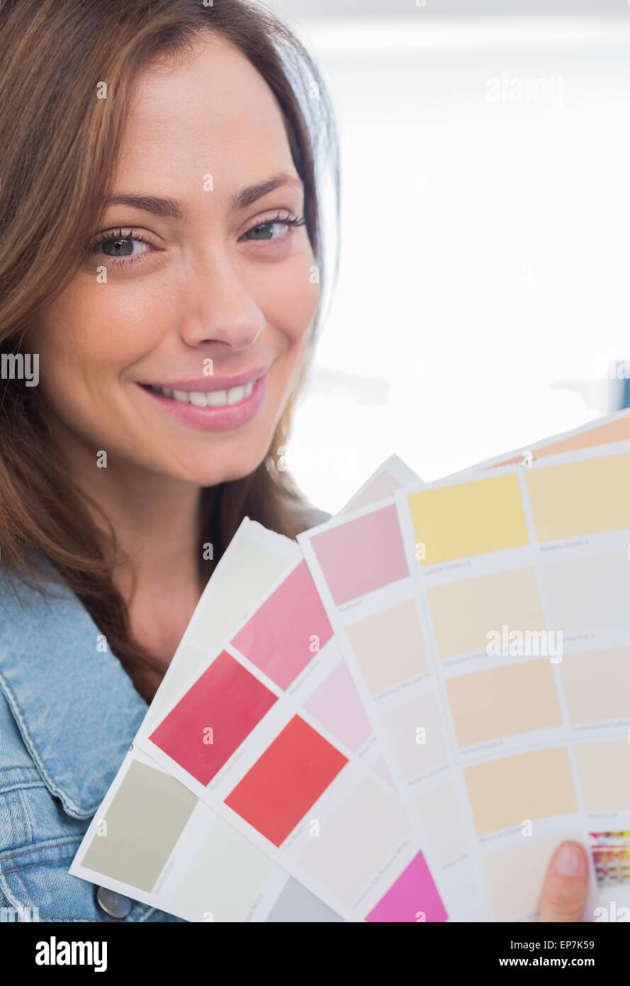 Attractive interior designer holding up colour samples Stock Photo - Alamy