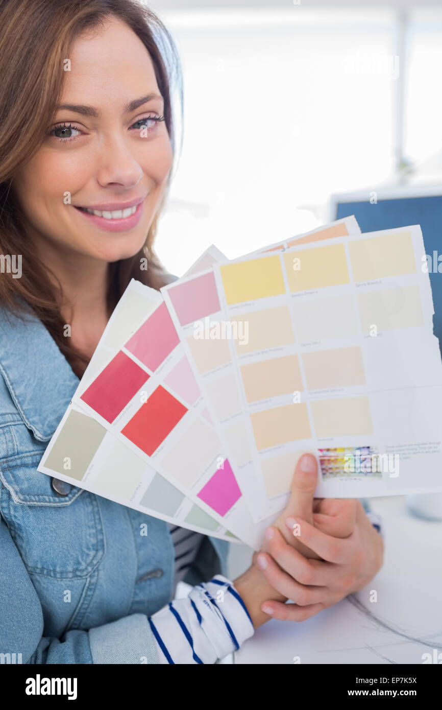 Cheerful interior designer holding up colour samples Stock Photo - Alamy