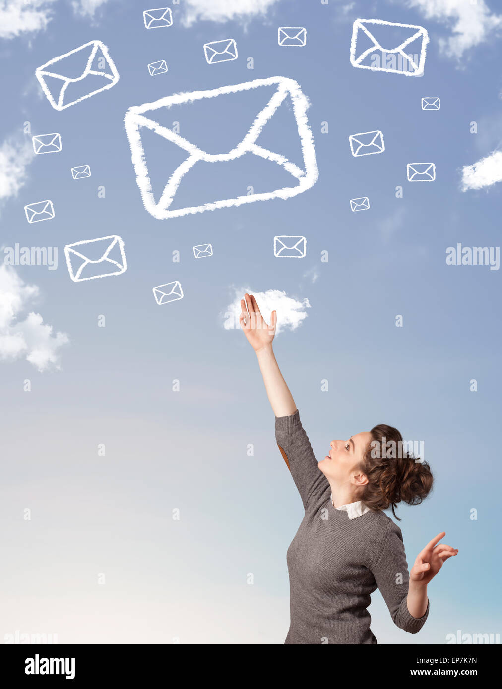 Young girl looking at mail symbol clouds on blue sky Stock Photo - Alamy