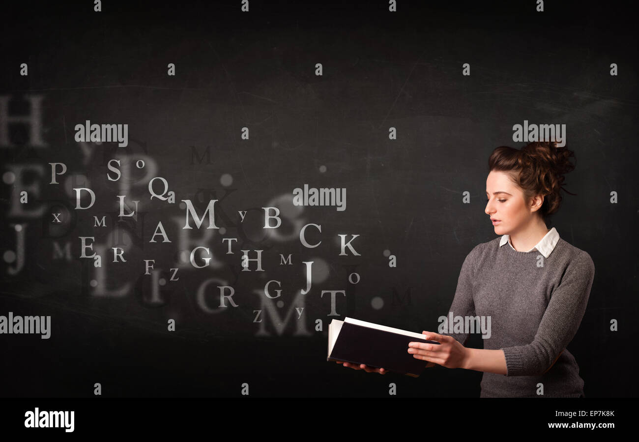 Young lady reading a book with alphabet letters Stock Photo - Alamy