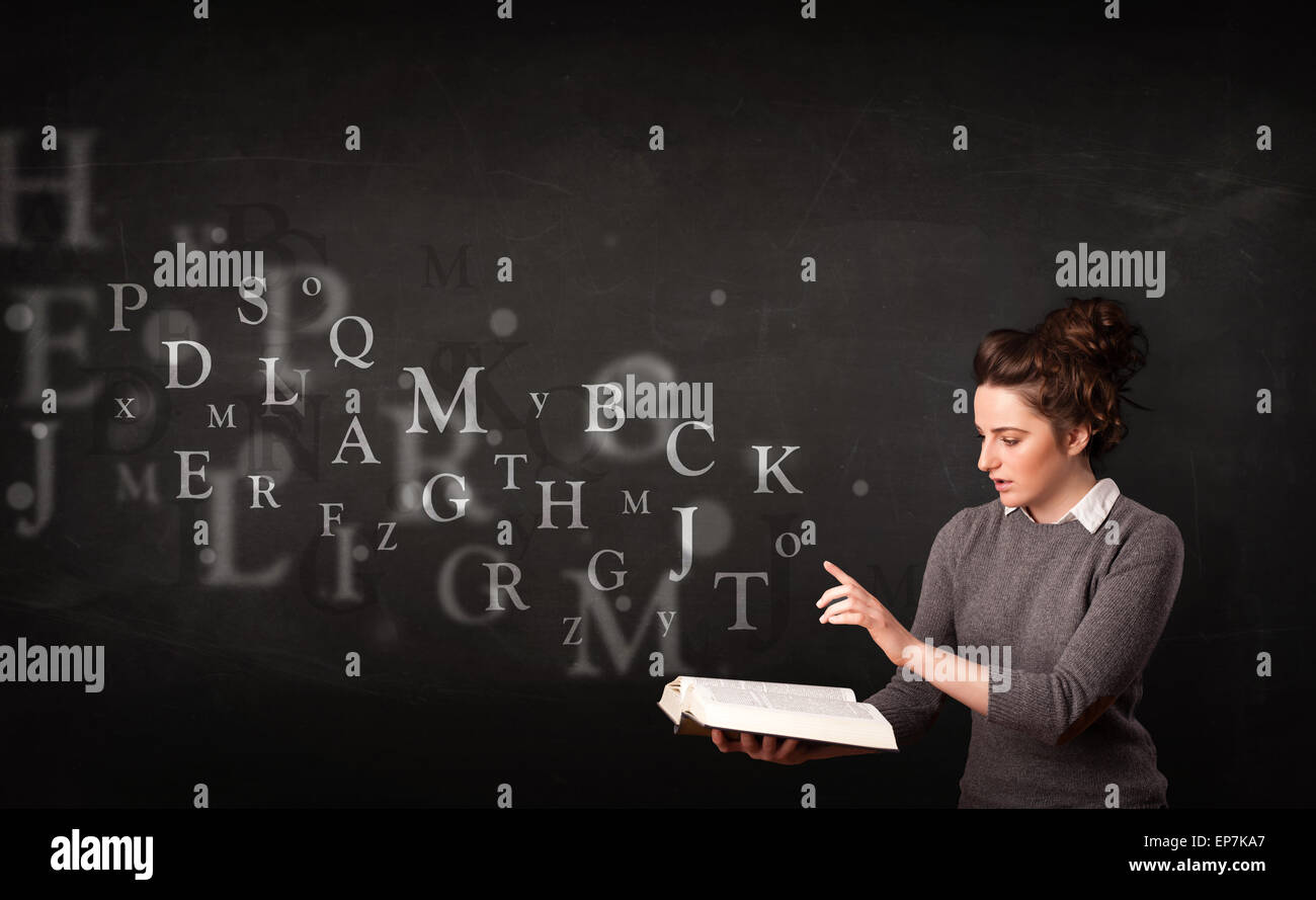 Young lady reading a book with alphabet letters Stock Photo - Alamy