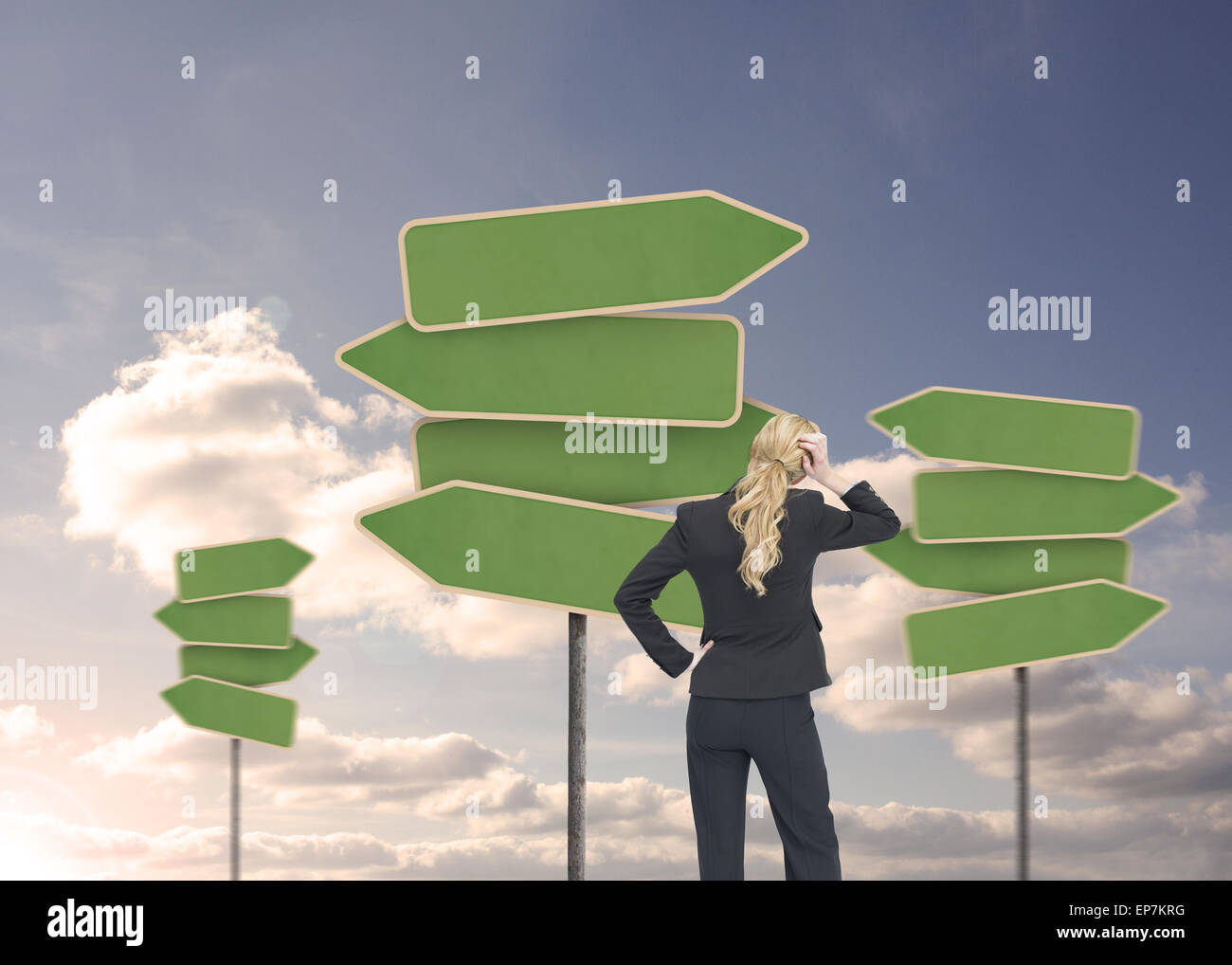 Rear view of a businesswoman looking at empty signposts Stock Photo - Alamy