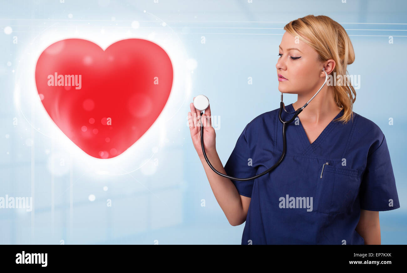 Young nurse healing a red heart Stock Photo - Alamy