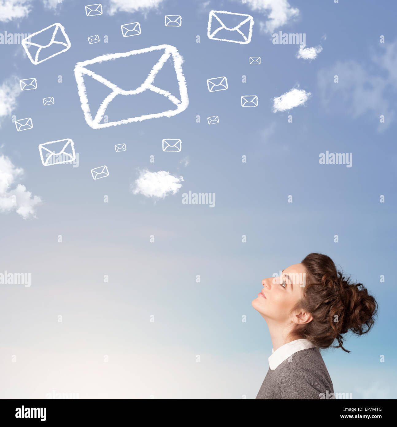 Young girl looking at mail symbol clouds on blue sky Stock Photo - Alamy