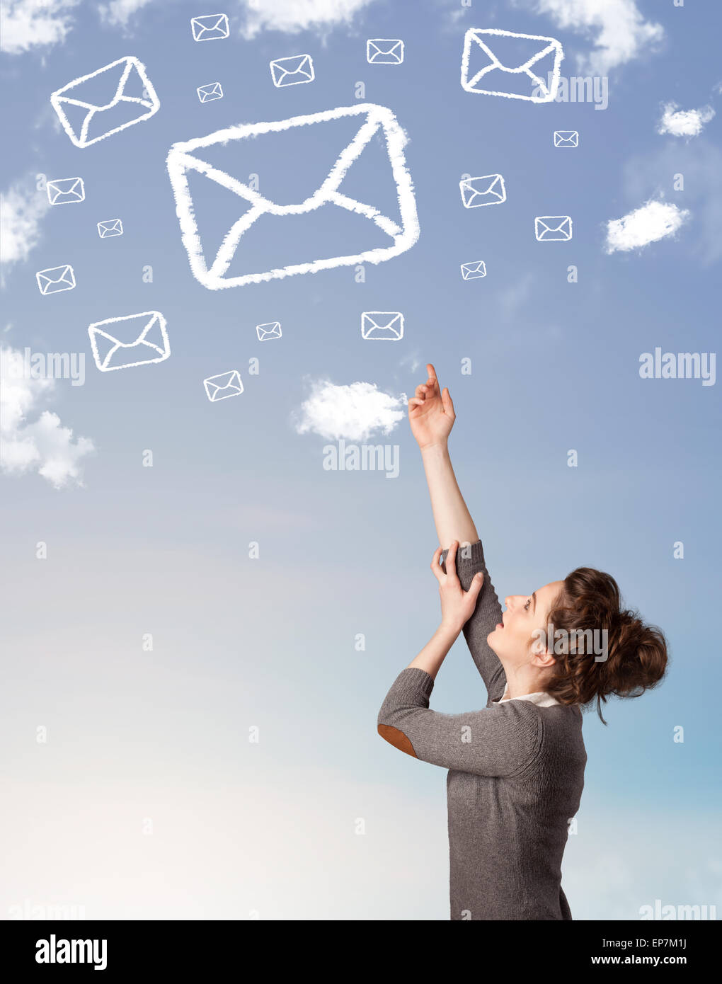 Young girl looking at mail symbol clouds on blue sky Stock Photo - Alamy