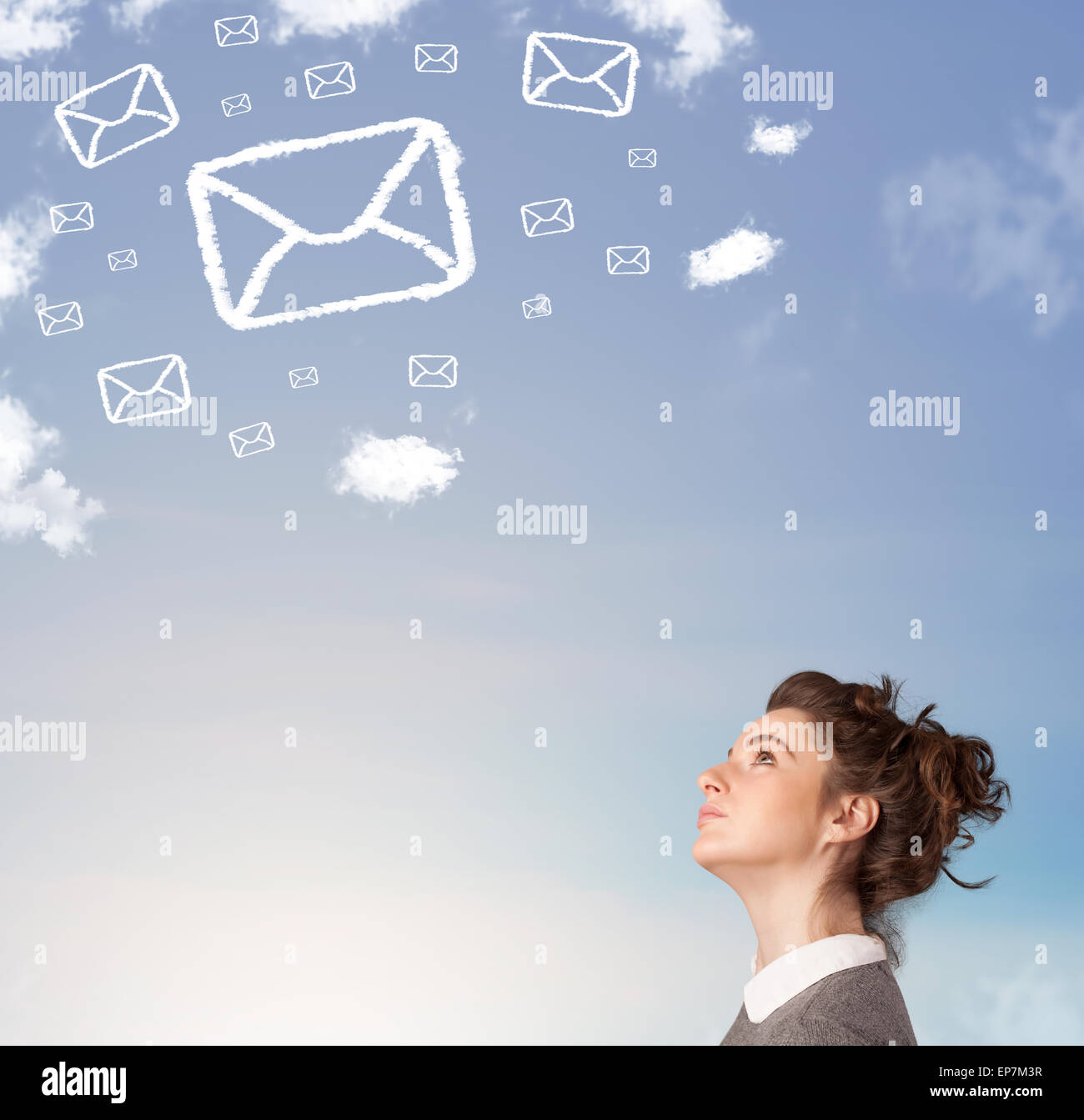 Young girl looking at mail symbol clouds on blue sky Stock Photo - Alamy