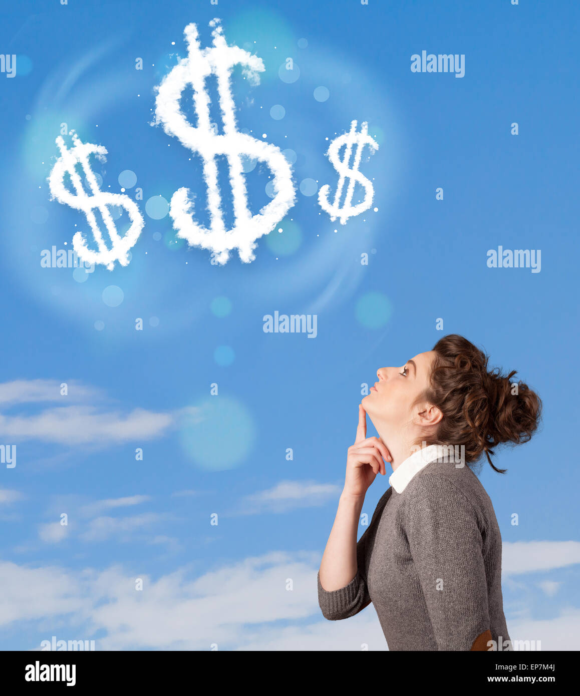 Young girl pointing at dollar sign clouds on blue sky Stock Photo - Alamy