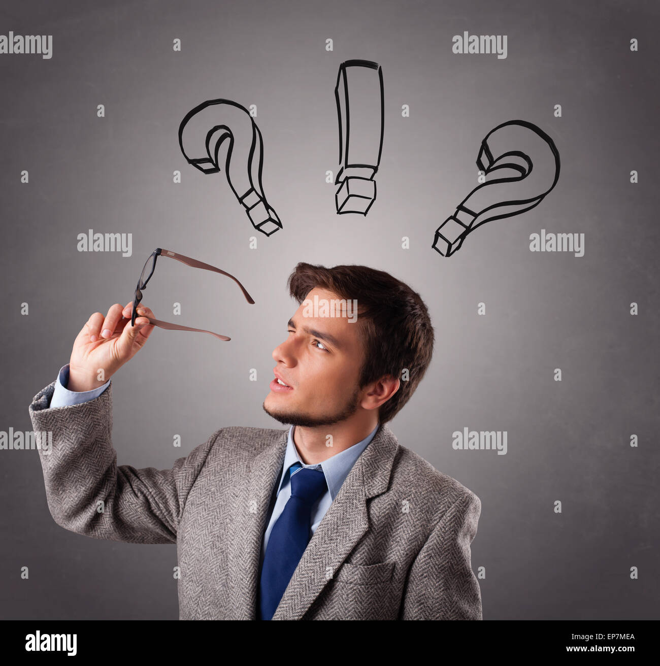 Young man thinking with question marks overhead Stock Photo - Alamy