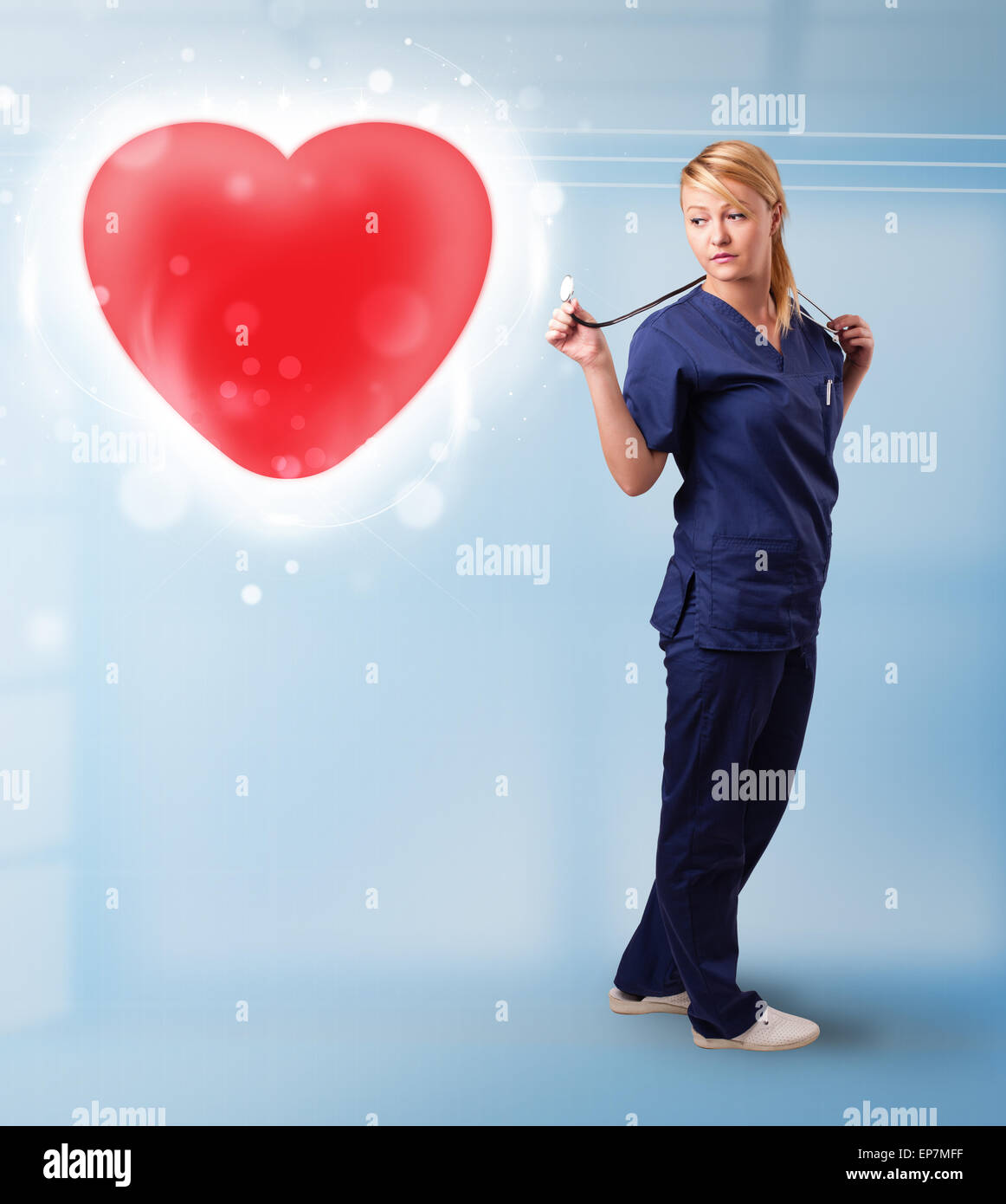 Young nurse healing a red heart Stock Photo - Alamy