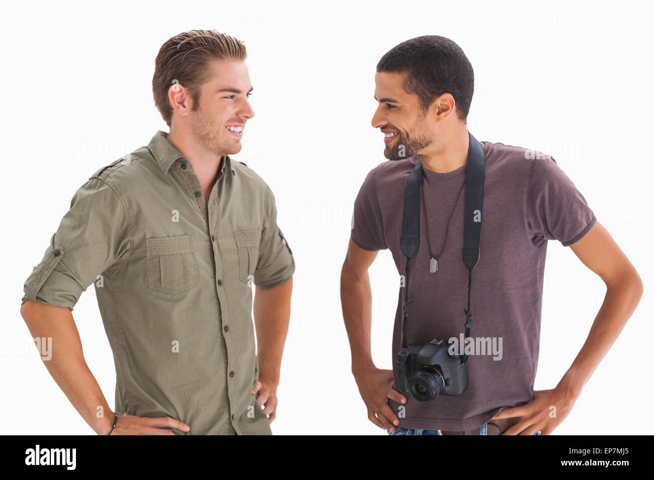 Stylish friends smiling at each other with one holding camera Stock ...