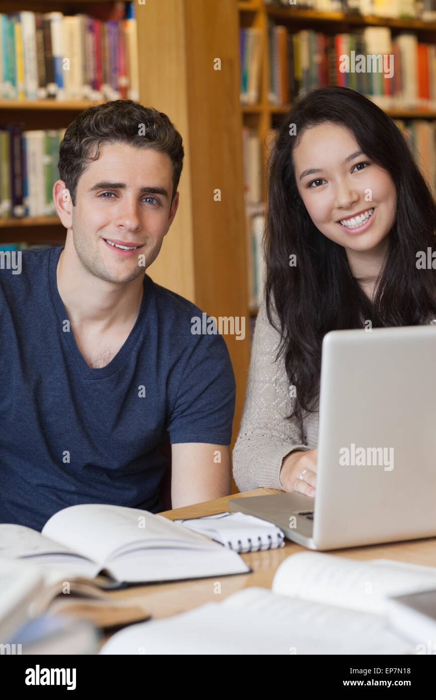 Two students learning with a laptop in a library Stock Photo - Alamy