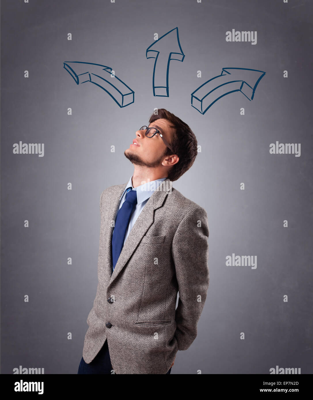 Handsome man thinking with arrows overhead Stock Photo - Alamy
