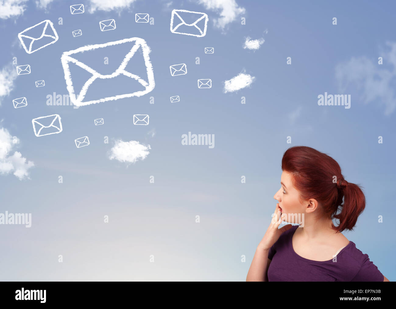 Young girl looking at mail symbol clouds on blue sky Stock Photo - Alamy