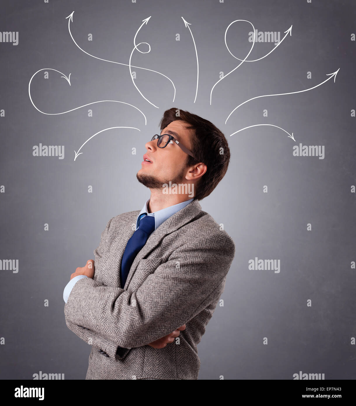 Young man thinking with arrows overhead Stock Photo - Alamy