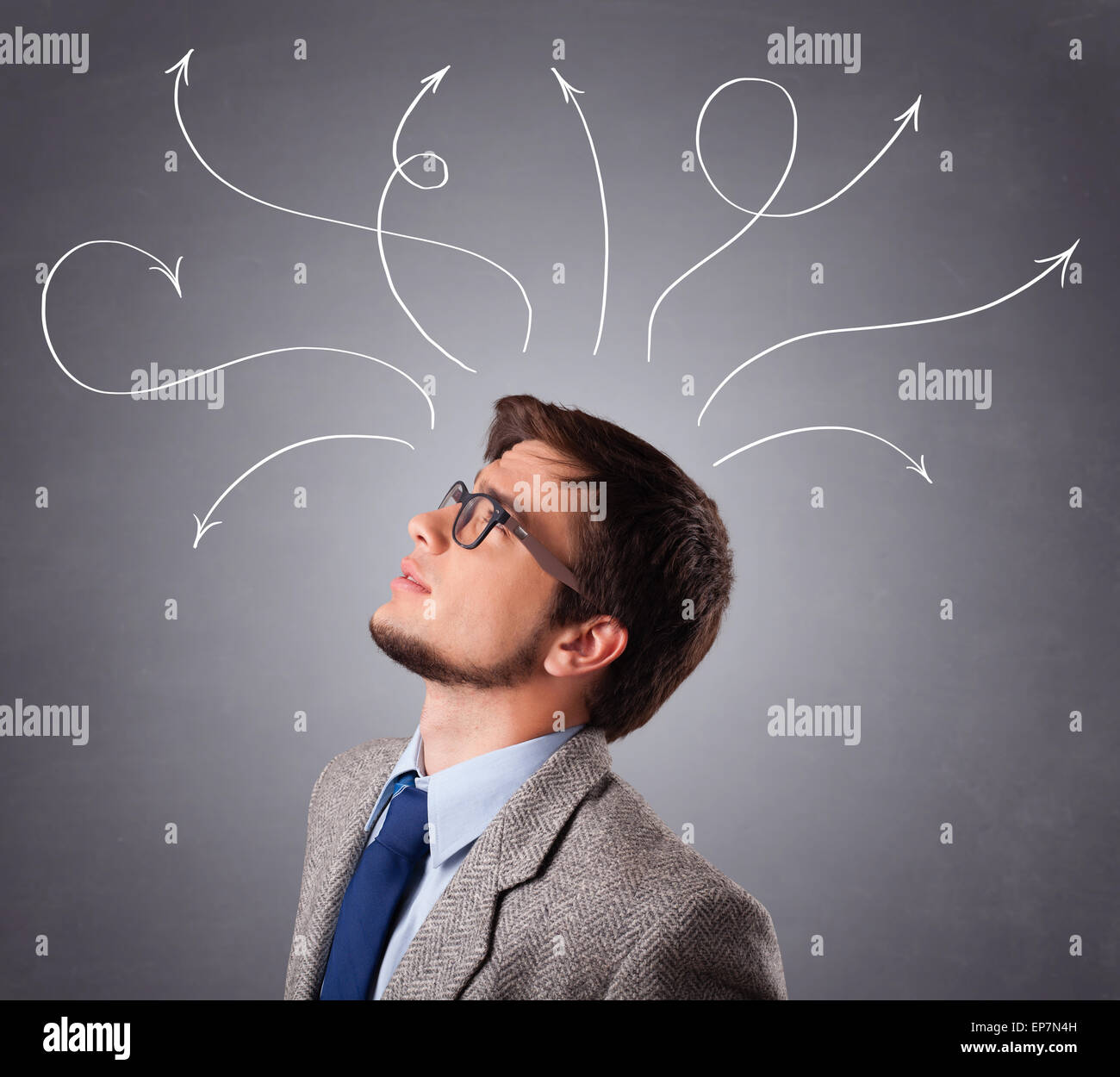 Young man thinking with arrows overhead Stock Photo - Alamy