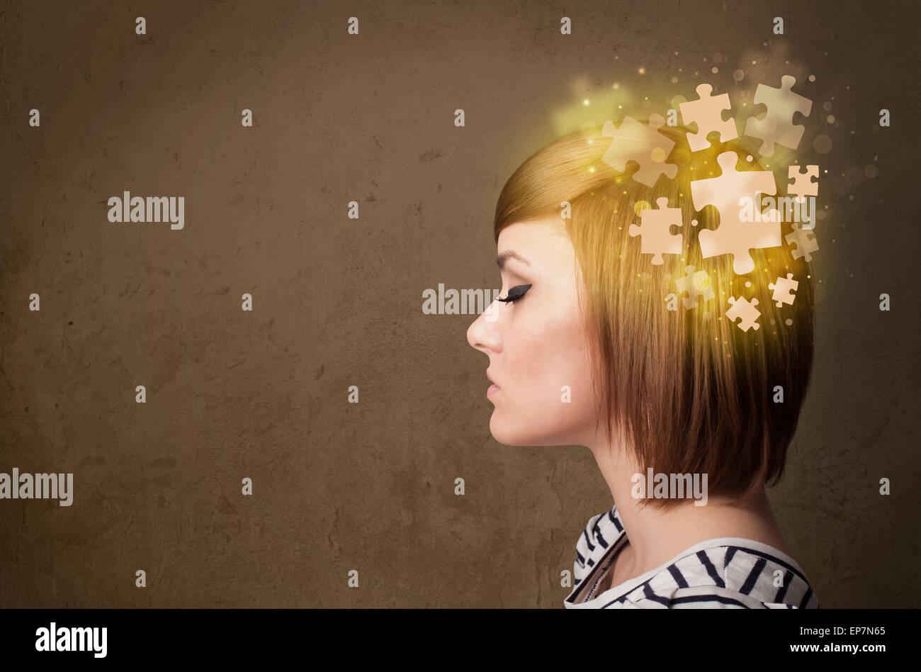 Young person thinking with glowing puzzle mind Stock Photo - Alamy