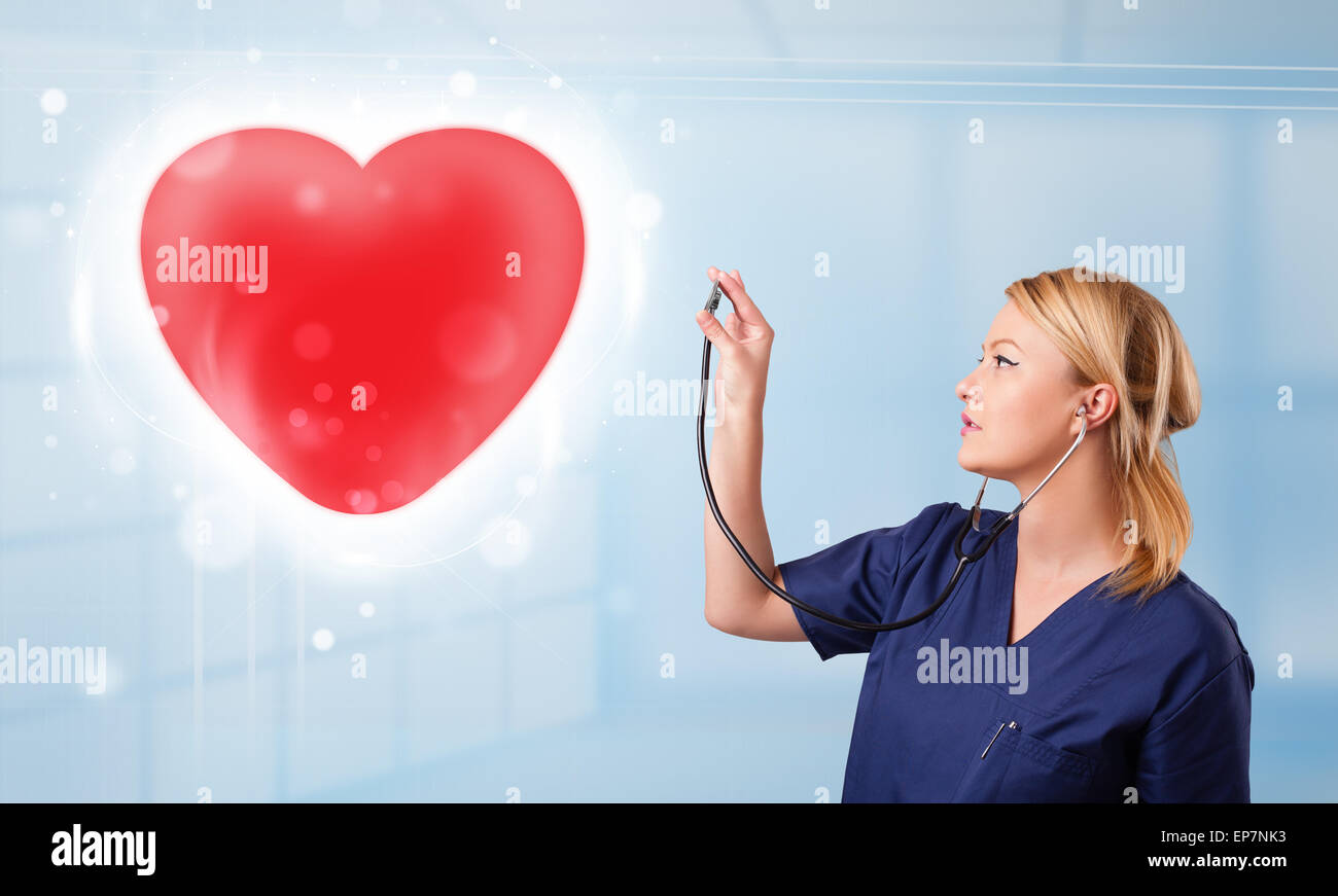 Young nurse healing a red heart Stock Photo - Alamy