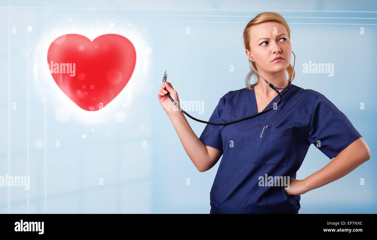 Young nurse healing a red heart Stock Photo - Alamy