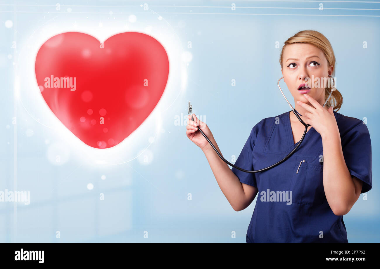 Young nurse healing a red heart Stock Photo - Alamy