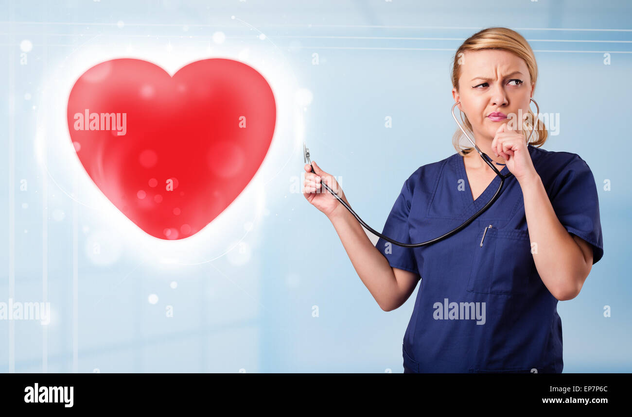 Young nurse healing a red heart Stock Photo - Alamy