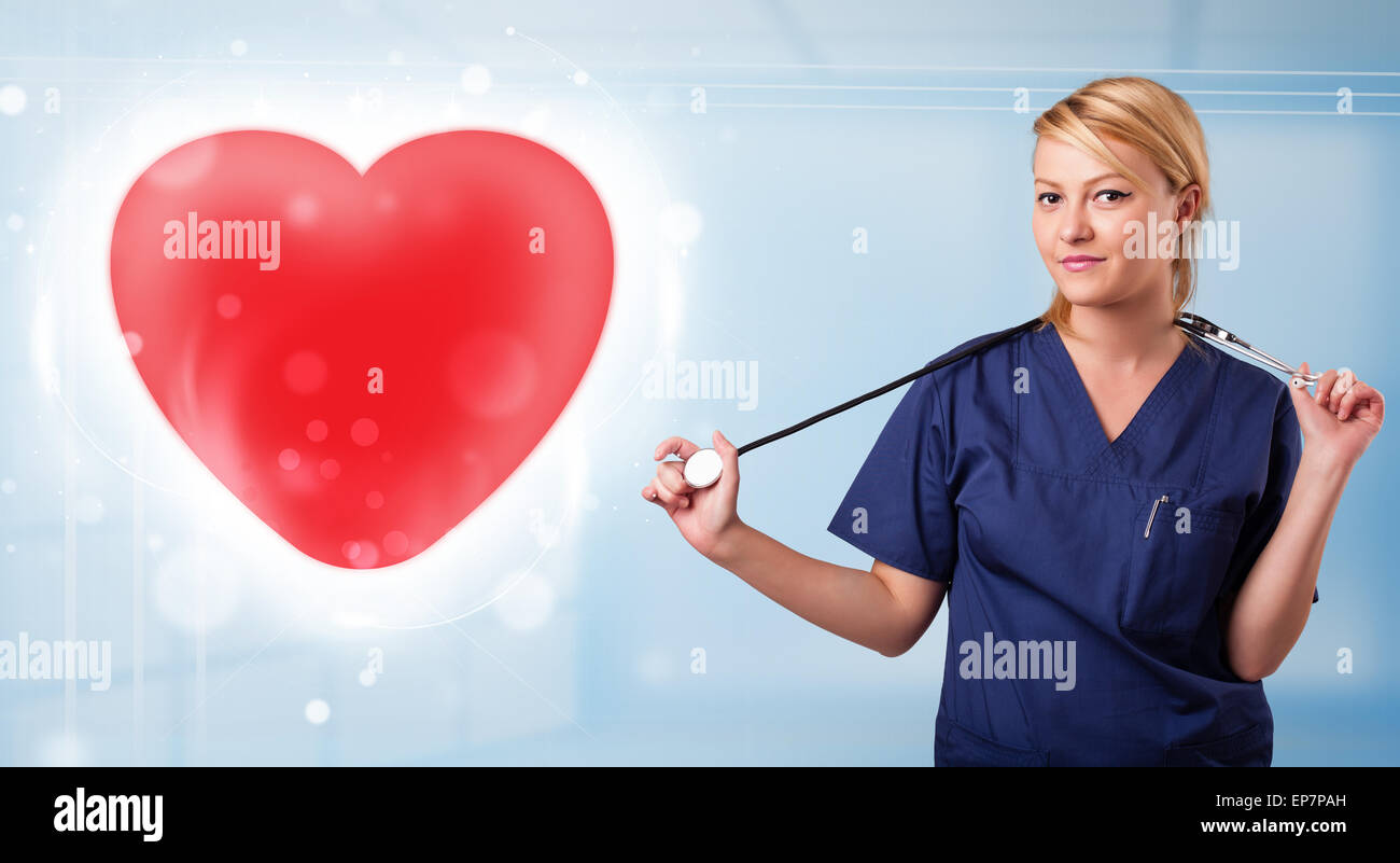 Young nurse healing a red heart Stock Photo - Alamy