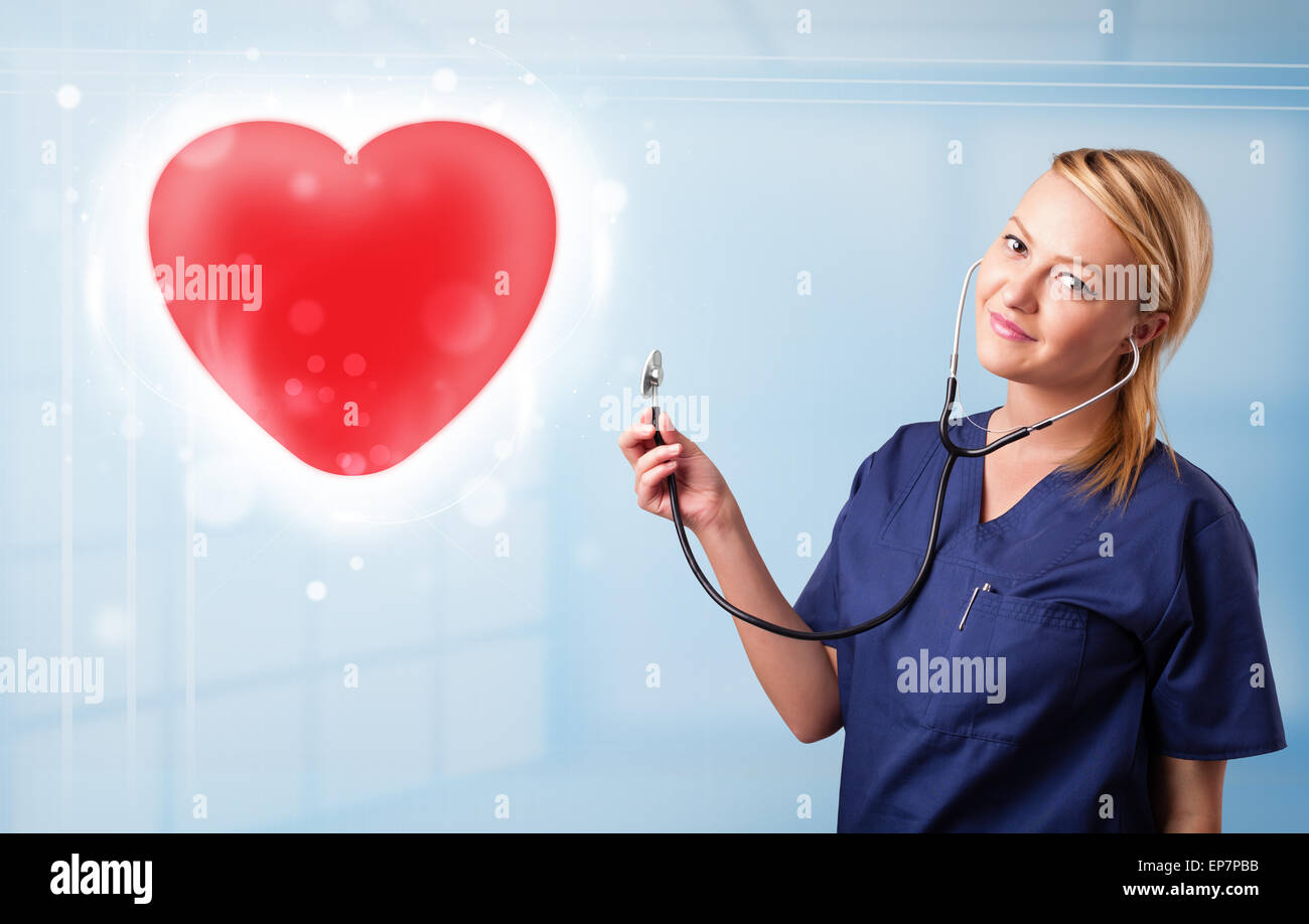 Young nurse healing a red heart Stock Photo - Alamy