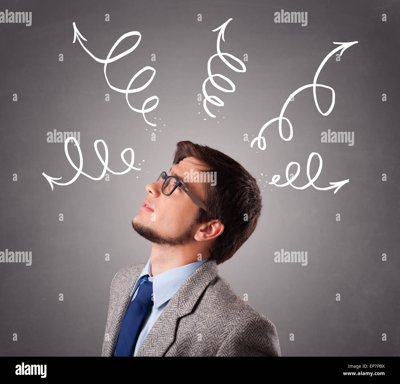 Young man thinking with arrows overhead Stock Photo - Alamy