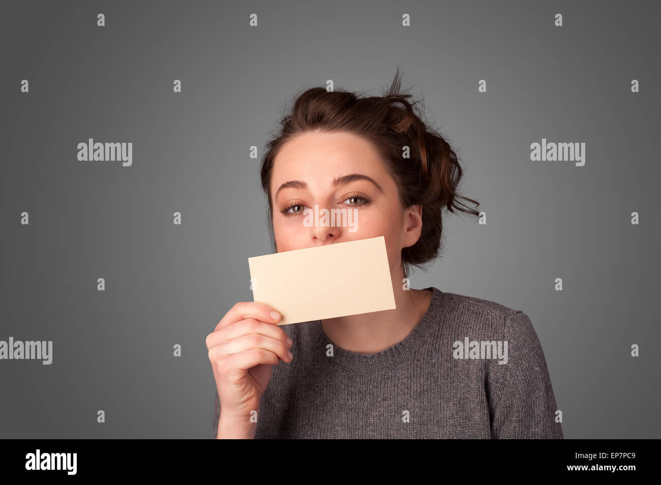Cute girl holding white card at front of her lips with copy space Stock ...
