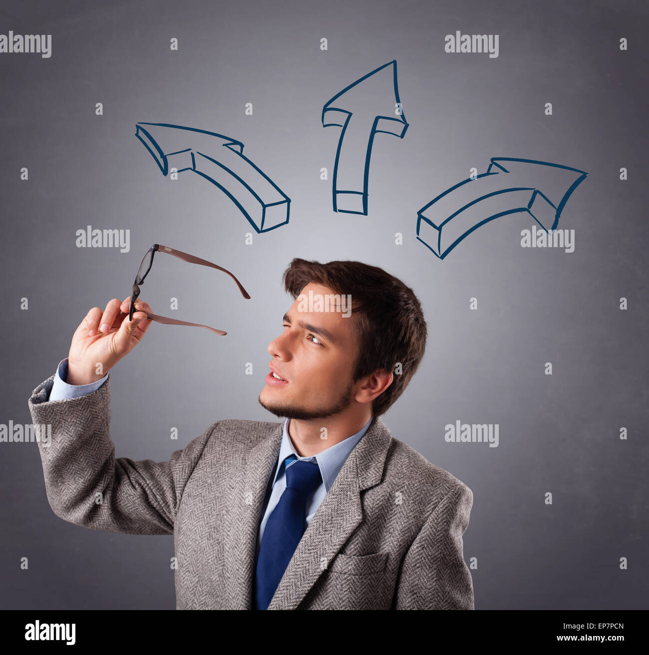 Handsome man thinking with arrows overhead Stock Photo - Alamy