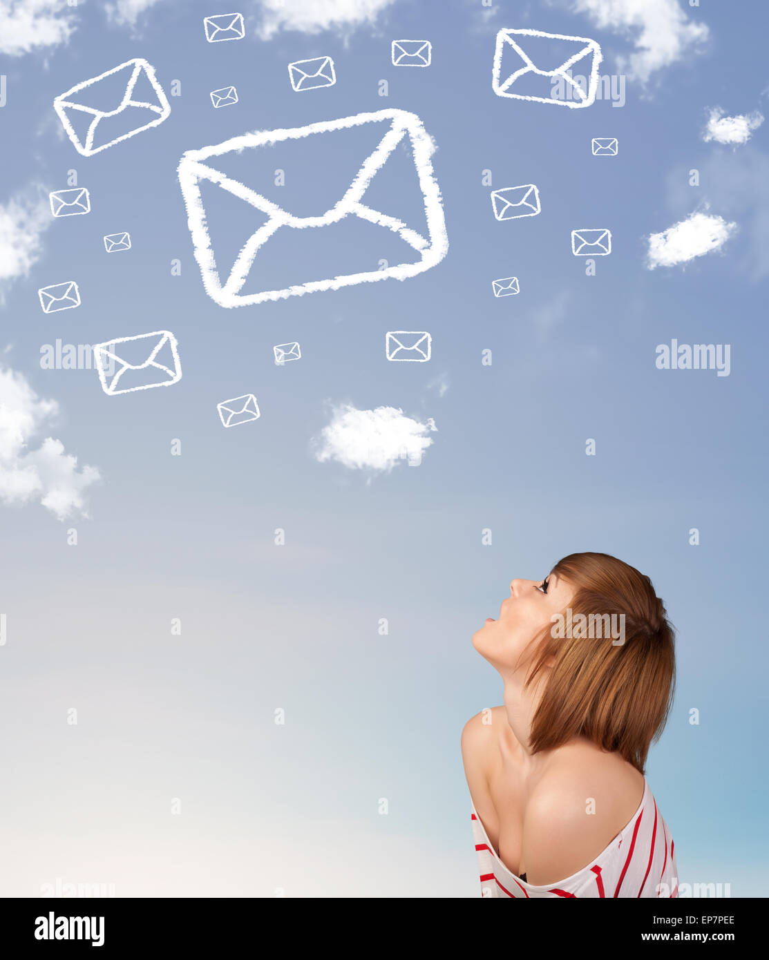 Young girl looking at mail symbol clouds on blue sky Stock Photo - Alamy