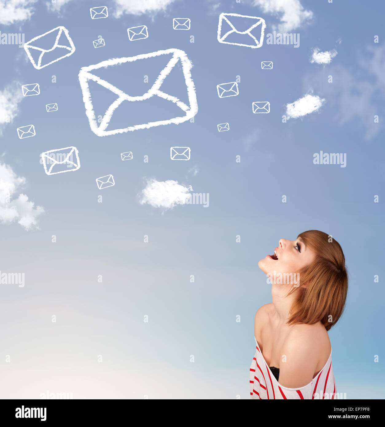 Young girl looking at mail symbol clouds on blue sky Stock Photo - Alamy
