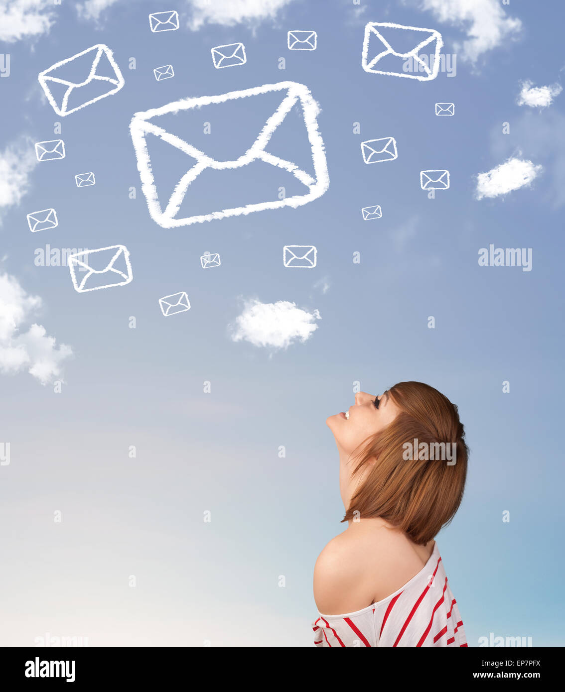 Young girl looking at mail symbol clouds on blue sky Stock Photo - Alamy