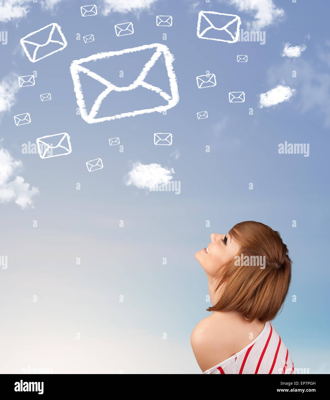 Young girl looking at mail symbol clouds on blue sky Stock Photo - Alamy