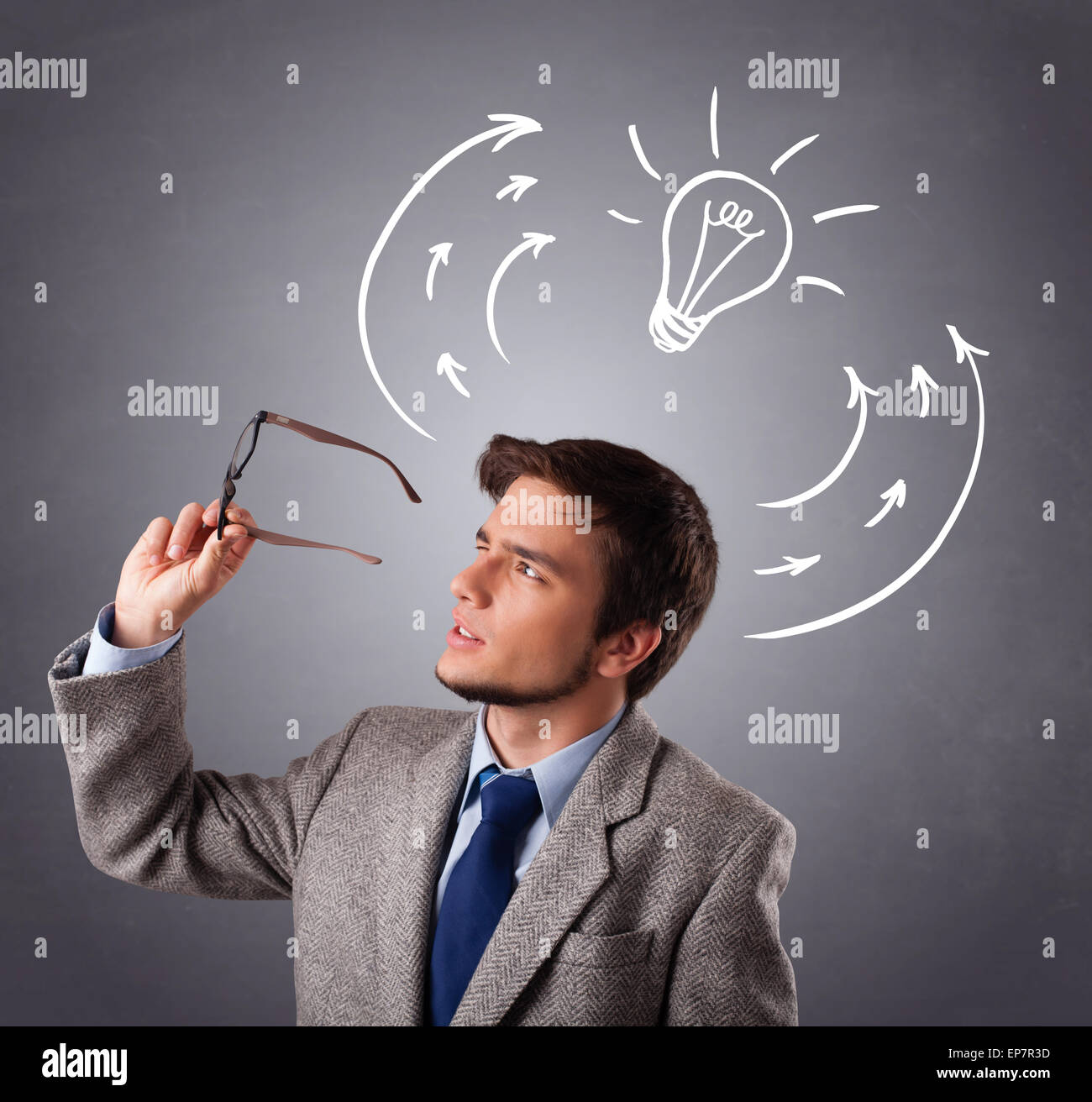 Young man thinking with arrows and light bulb overhead Stock Photo - Alamy