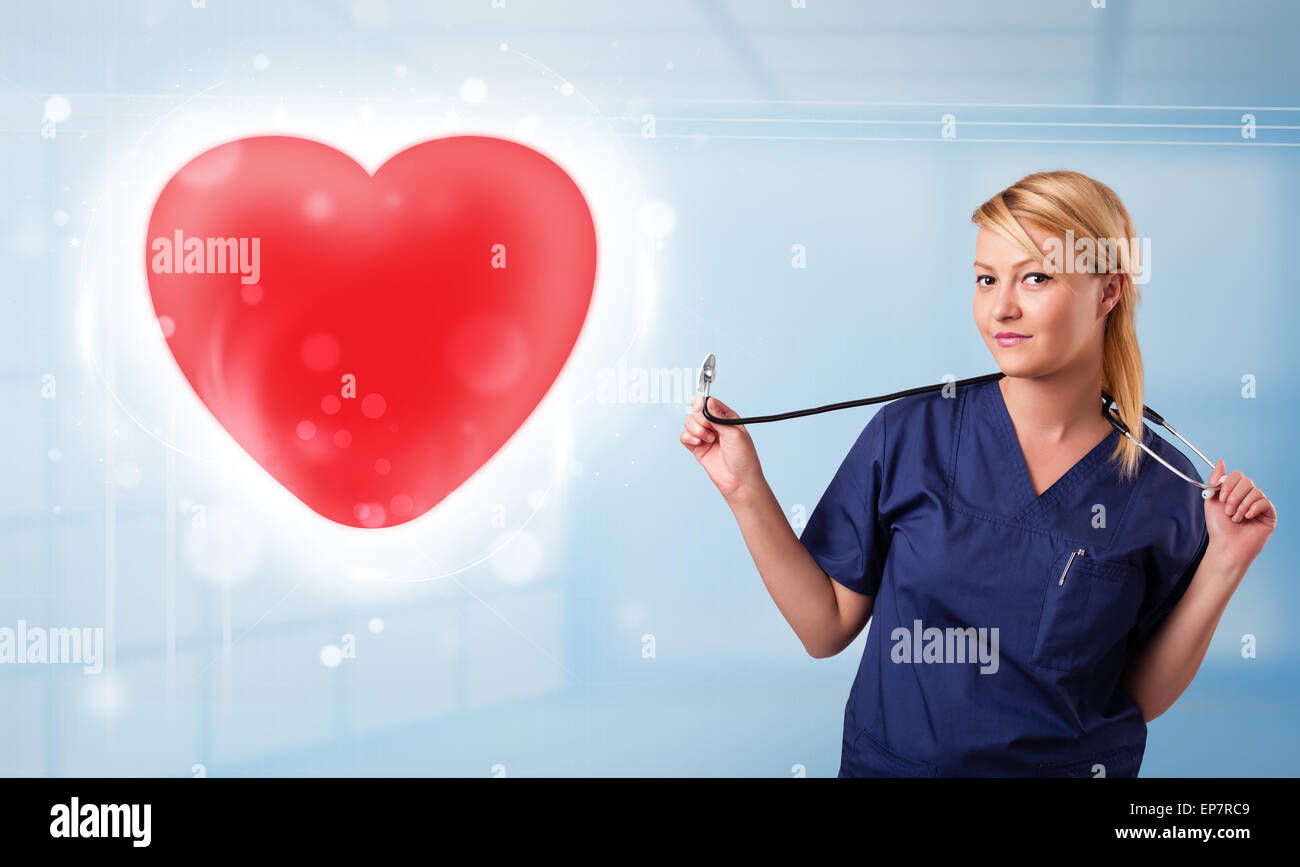 Young nurse healing a red heart Stock Photo - Alamy