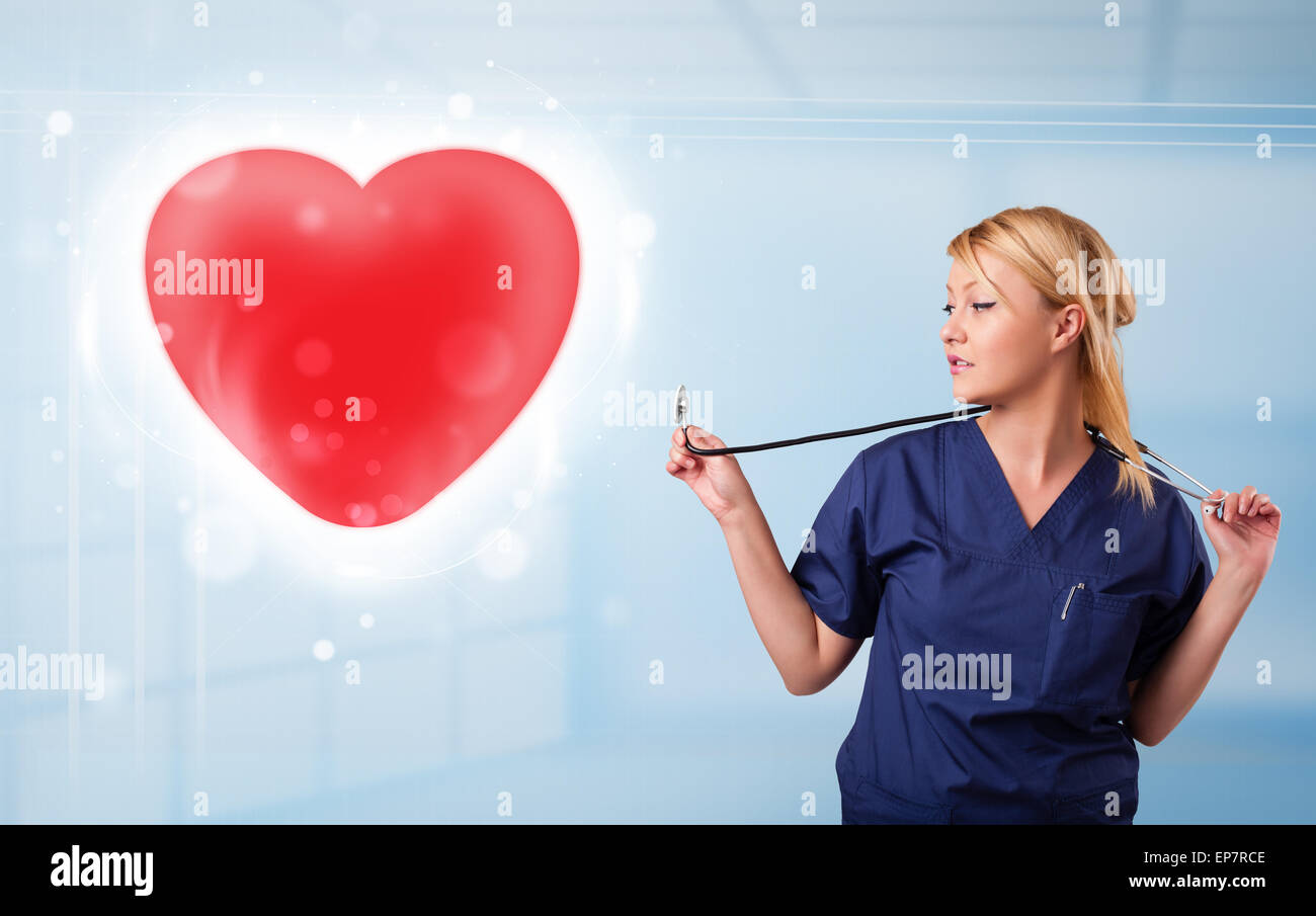 Young nurse healing a red heart Stock Photo - Alamy
