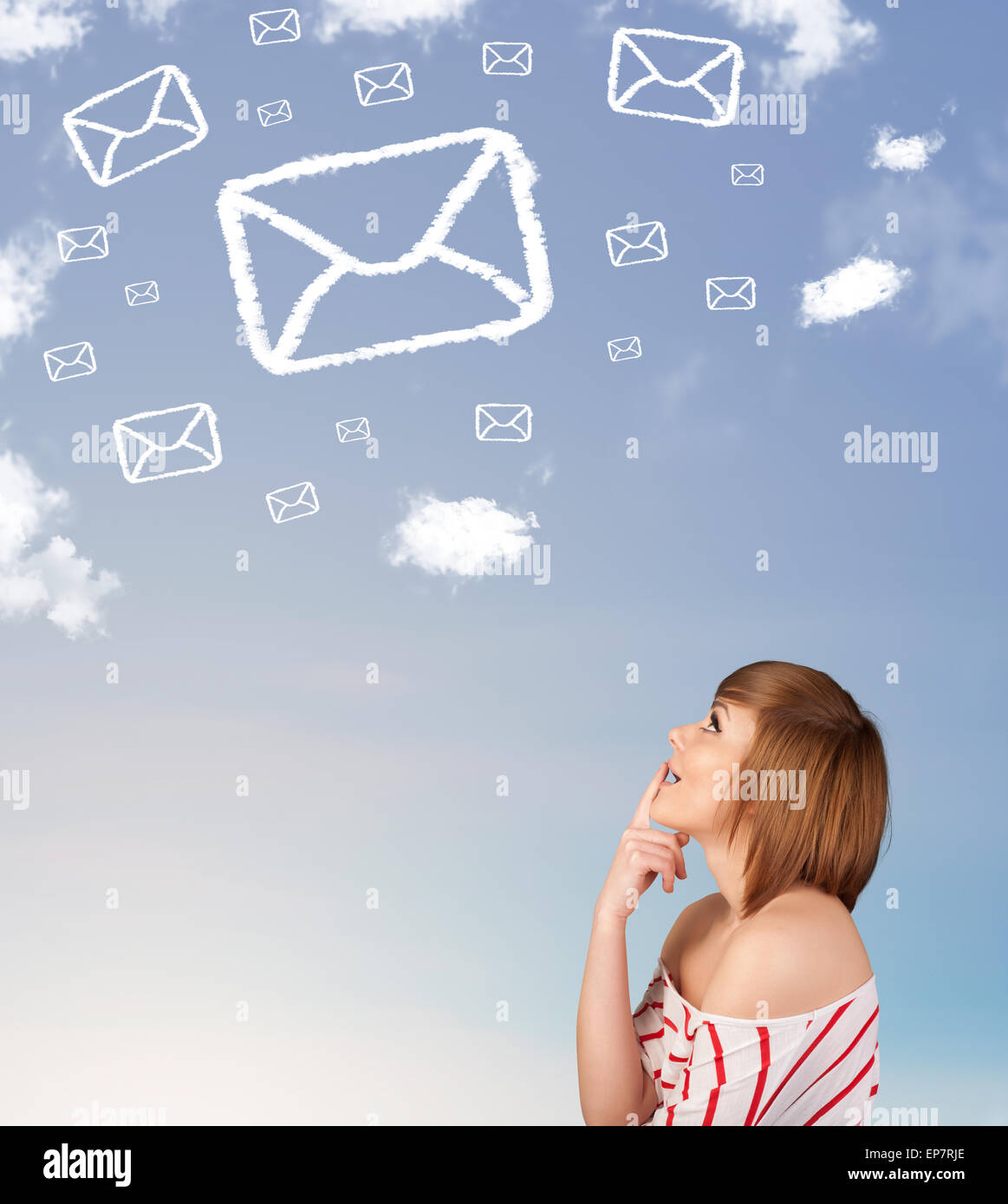 Young girl looking at mail symbol clouds on blue sky Stock Photo - Alamy