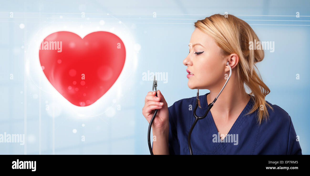Young nurse healing a red heart Stock Photo - Alamy